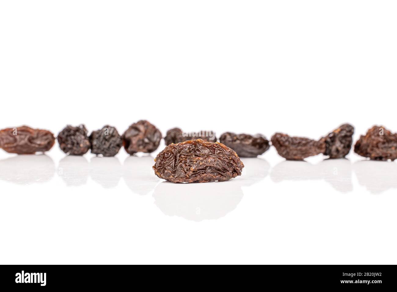 Lot of whole dried dark raisin one in front isolated on white ...
