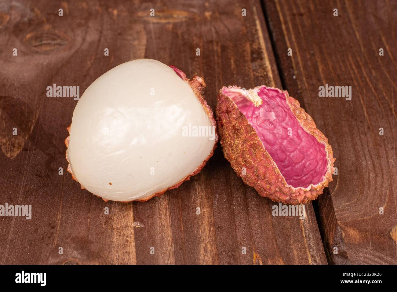 Group of one whole one piece of peeled fresh lychee on brown wood Stock ...