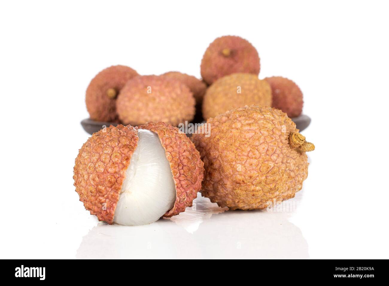 Group of eight whole fresh lychee in glazed bowl isolated on white ...