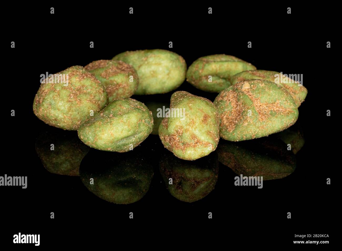 Group of eight whole wasabi green peanut circle isolated on black glass ...