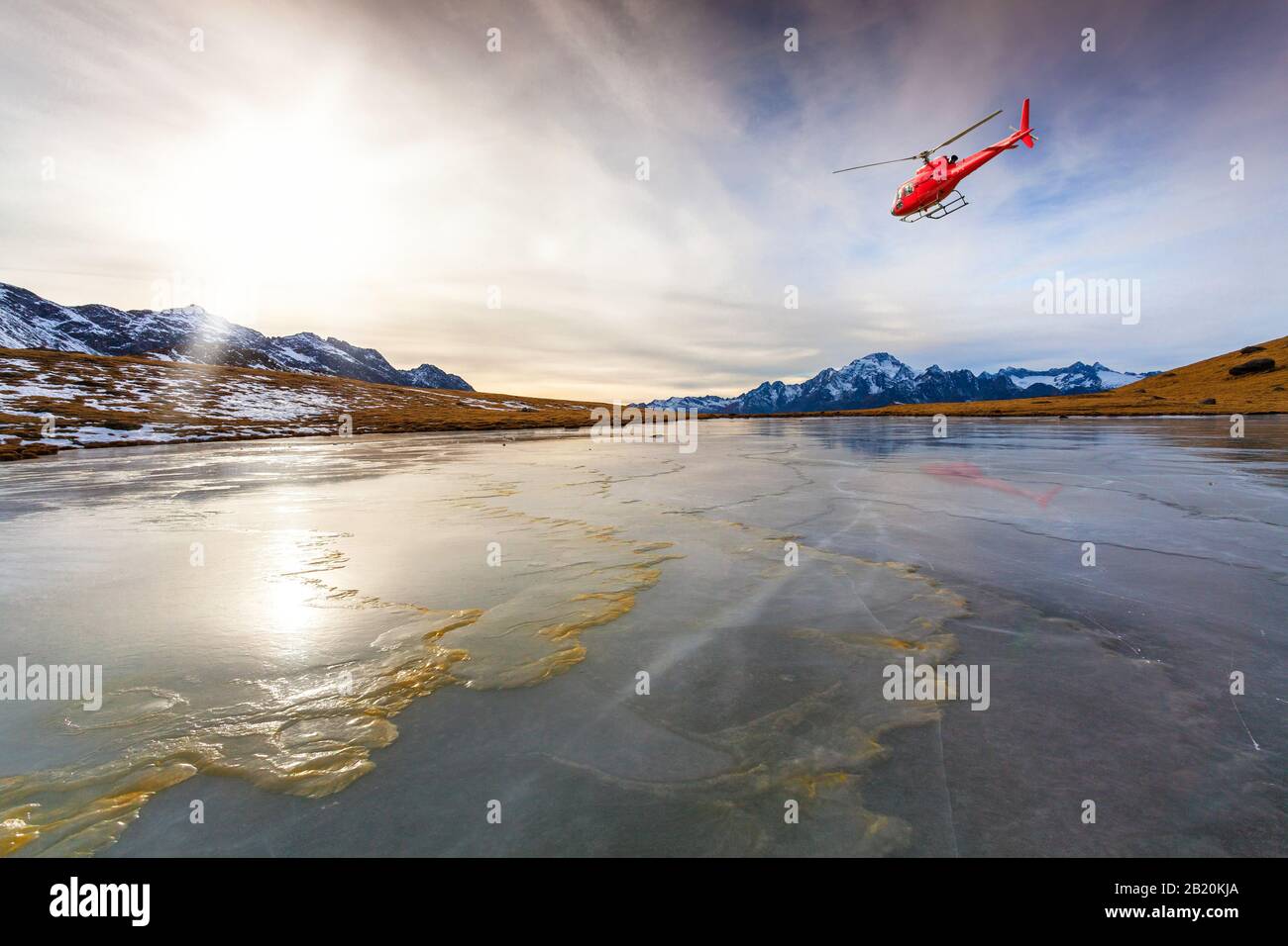 Red helicopter in flight on frozen lake Stock Photo - Alamy
