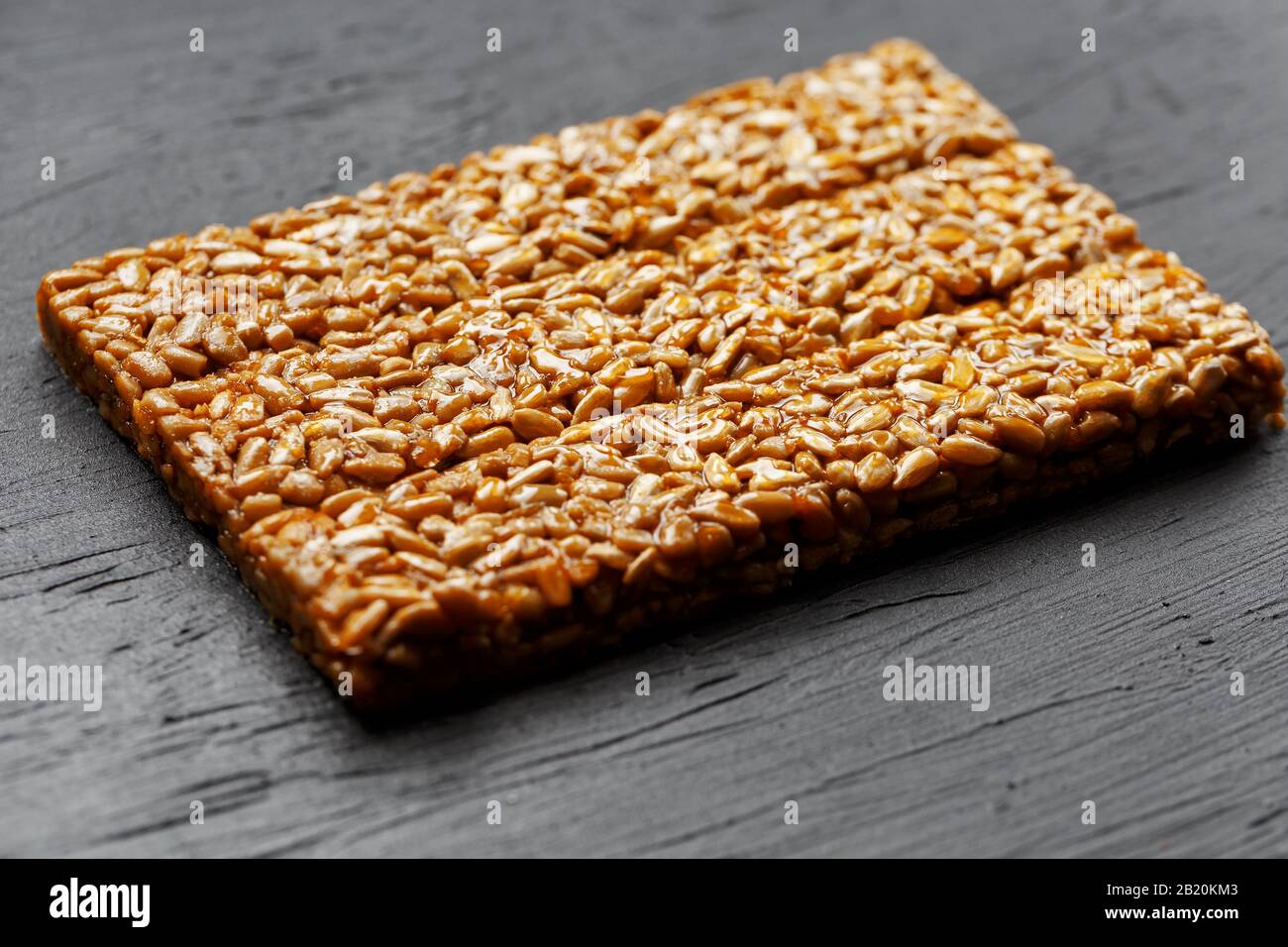 Tile kozinaki from sunflower seeds on a black textural background ...