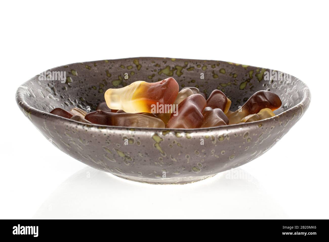 Lot of whole sweet jelly cola in glazed bowl isolated on white ...