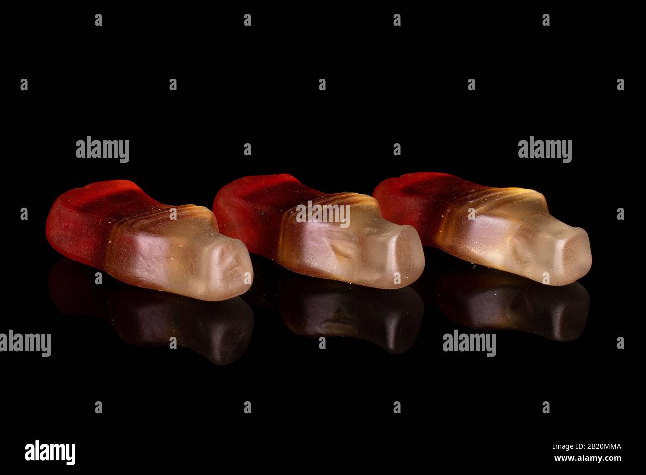 Group of three whole sweet jelly cola isolated on black glass Stock ...