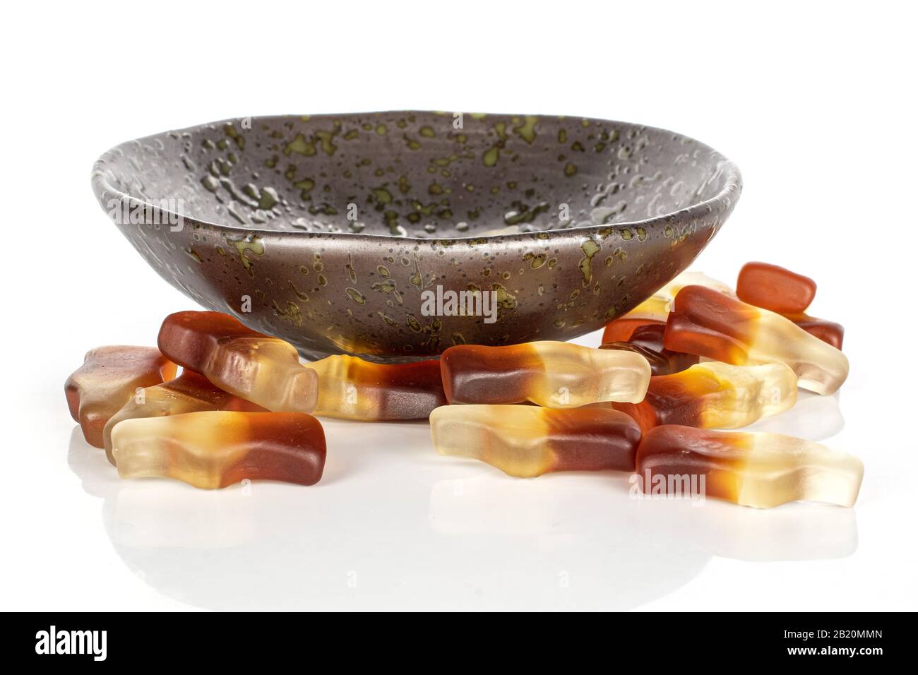 Lot of whole disordered sweet jelly cola in glazed bowl isolated on ...