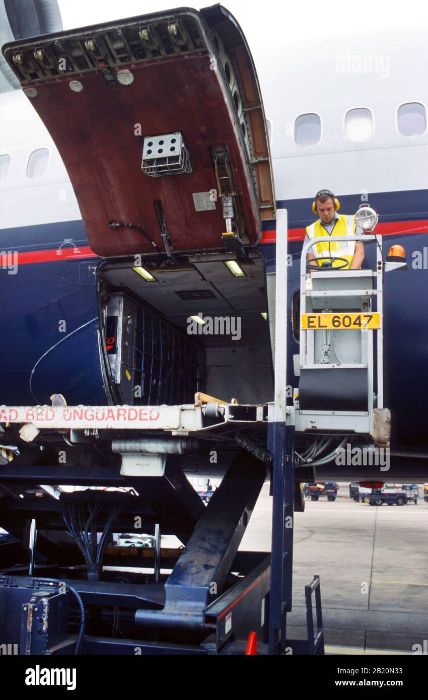 Baggage handlers (fleet service clerks) loading an airplane Stock Photo ...