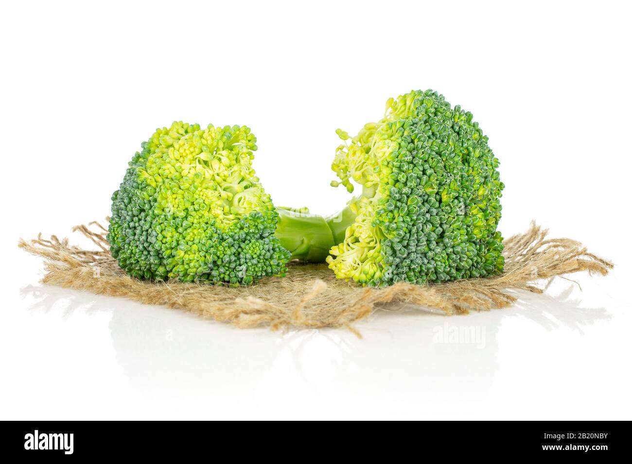 Group of two whole fresh green broccoli head on natural sackcloth ...