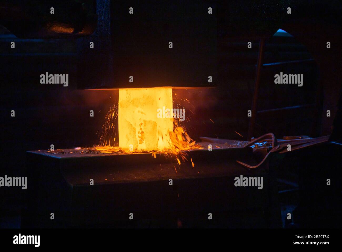 close-up picture of hot steel manual forging process with big ...