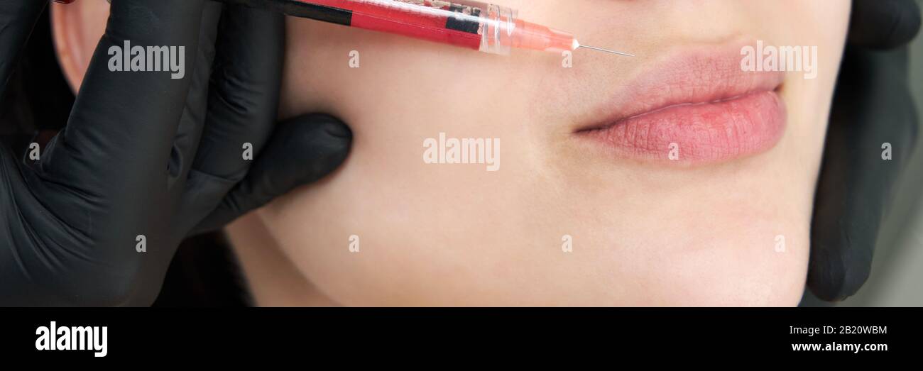 Beautiful woman gets an injection in lips Stock Photo - Alamy