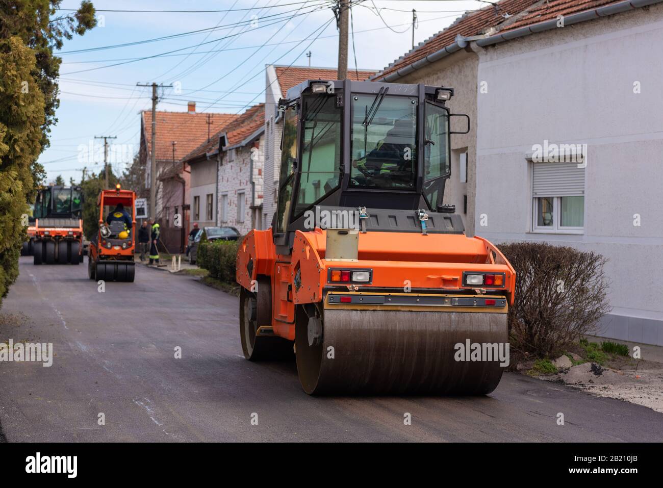 Workers with machinery preparing the road for new asphalt Stock Photo ...