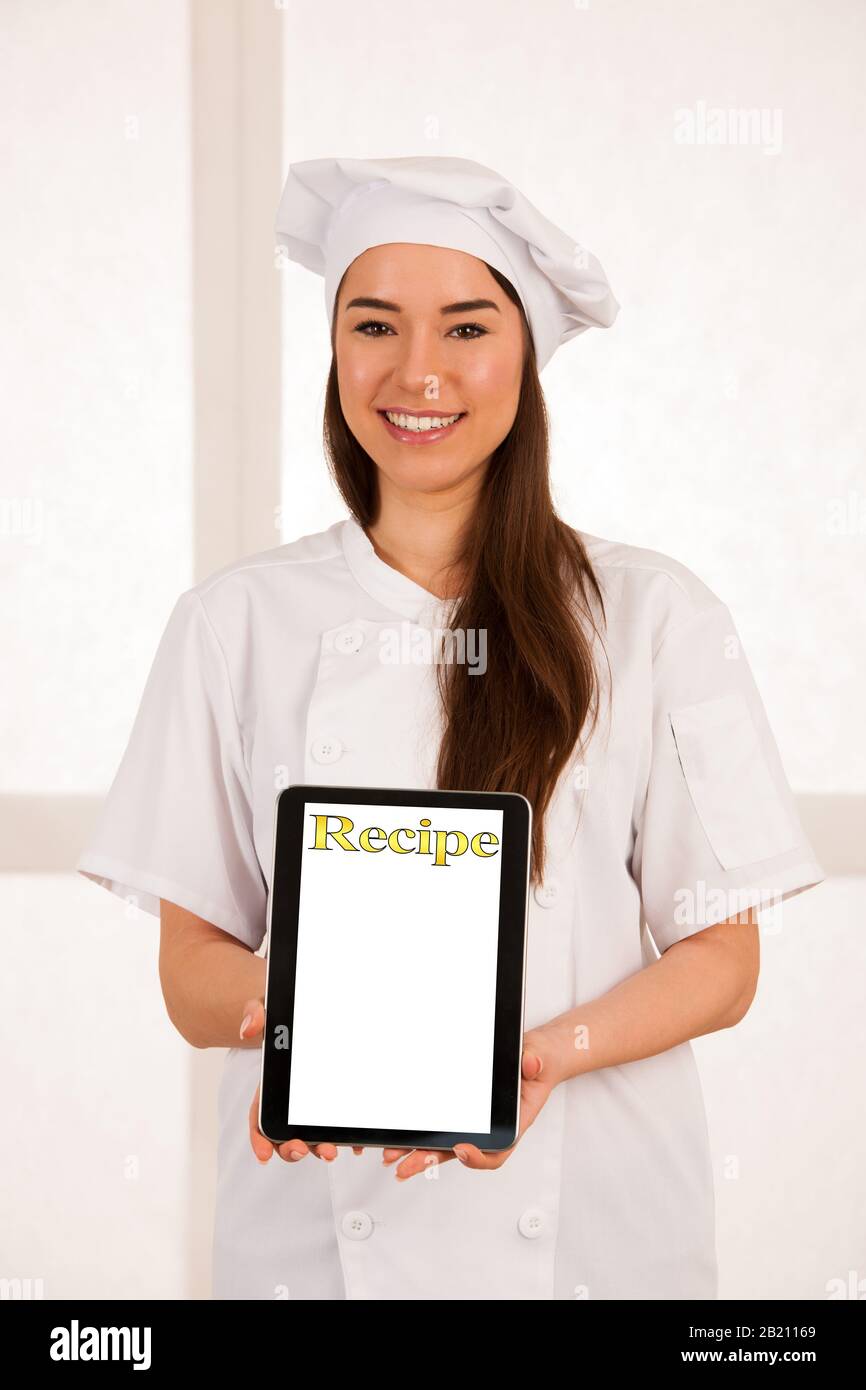 young blonde chef woamn holds kitchenware as she prepares to cook a ...