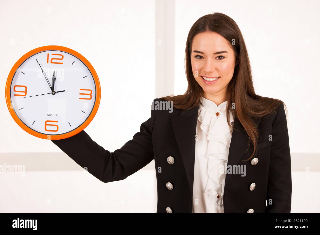 cute woman holding a clock as a symbol of time management Stock Photo ...