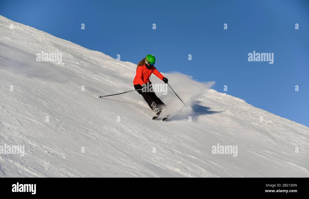 Skier descending steep slope, black piste, blue sky, SkiWelt Wilder ...