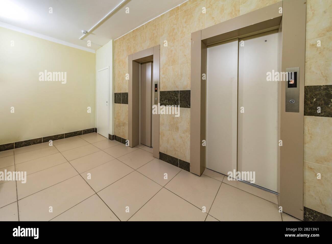 empty modern elevator or lift with closed metal doors brown tile design ...