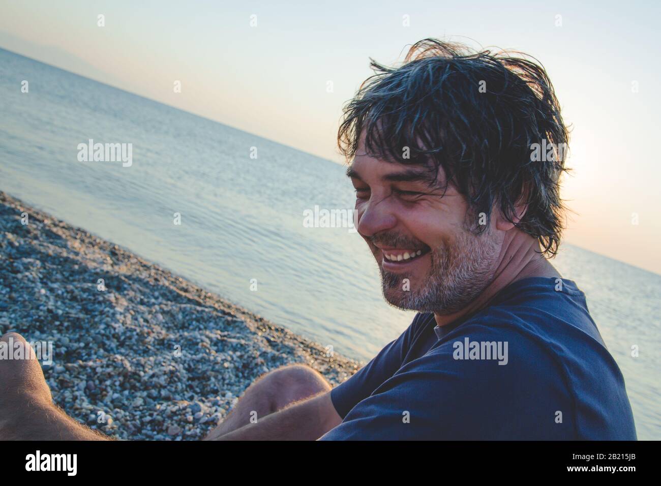 Handsome man relaxing on the beach in Greece while sunsets / Portrait ...