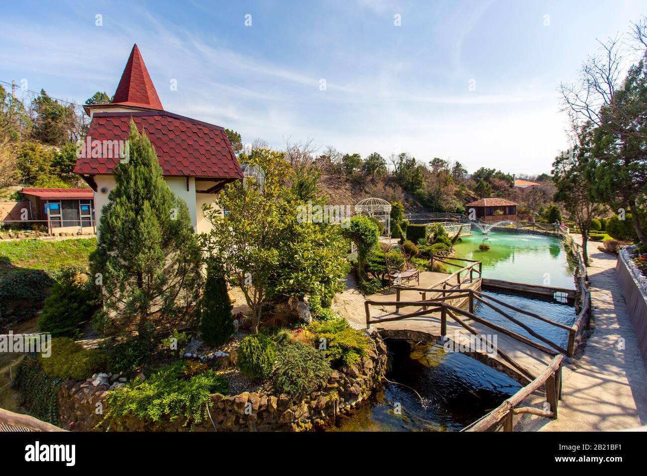 An elegant white house with turrets and a red roof on a trout lake ...