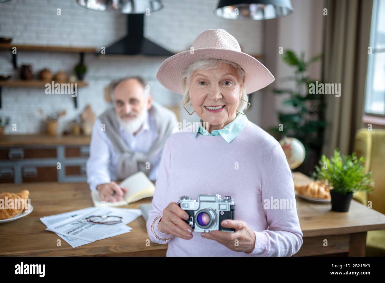 Smiling stylish elderly woman holding a film camera Stock Photo - Alamy