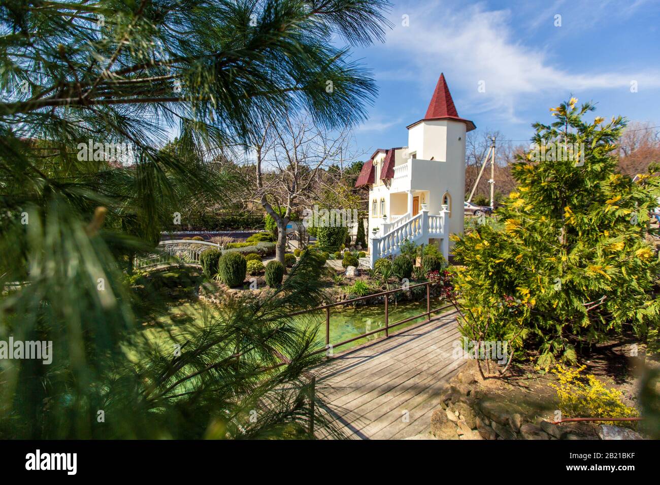 An elegant white house with turrets and a red roof on a trout lake ...