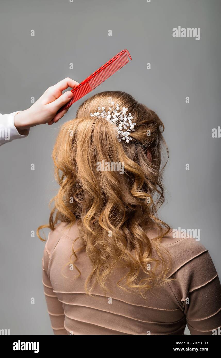 Wave curls hairstyle. Hairdresser making hairstyle to blond hair woman ...