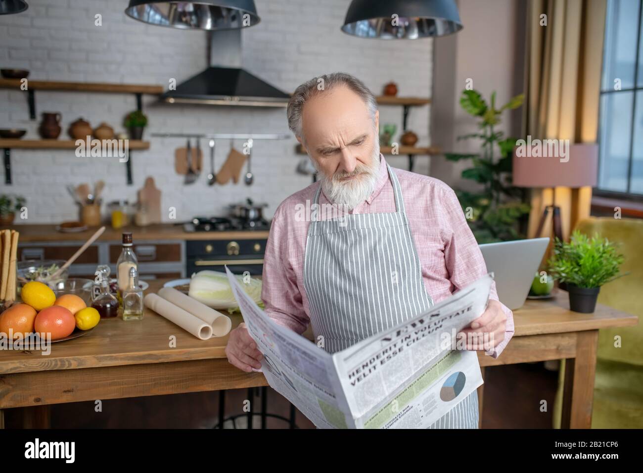 Thoughtful elderly man reading a daily newspaper Stock Photo - Alamy