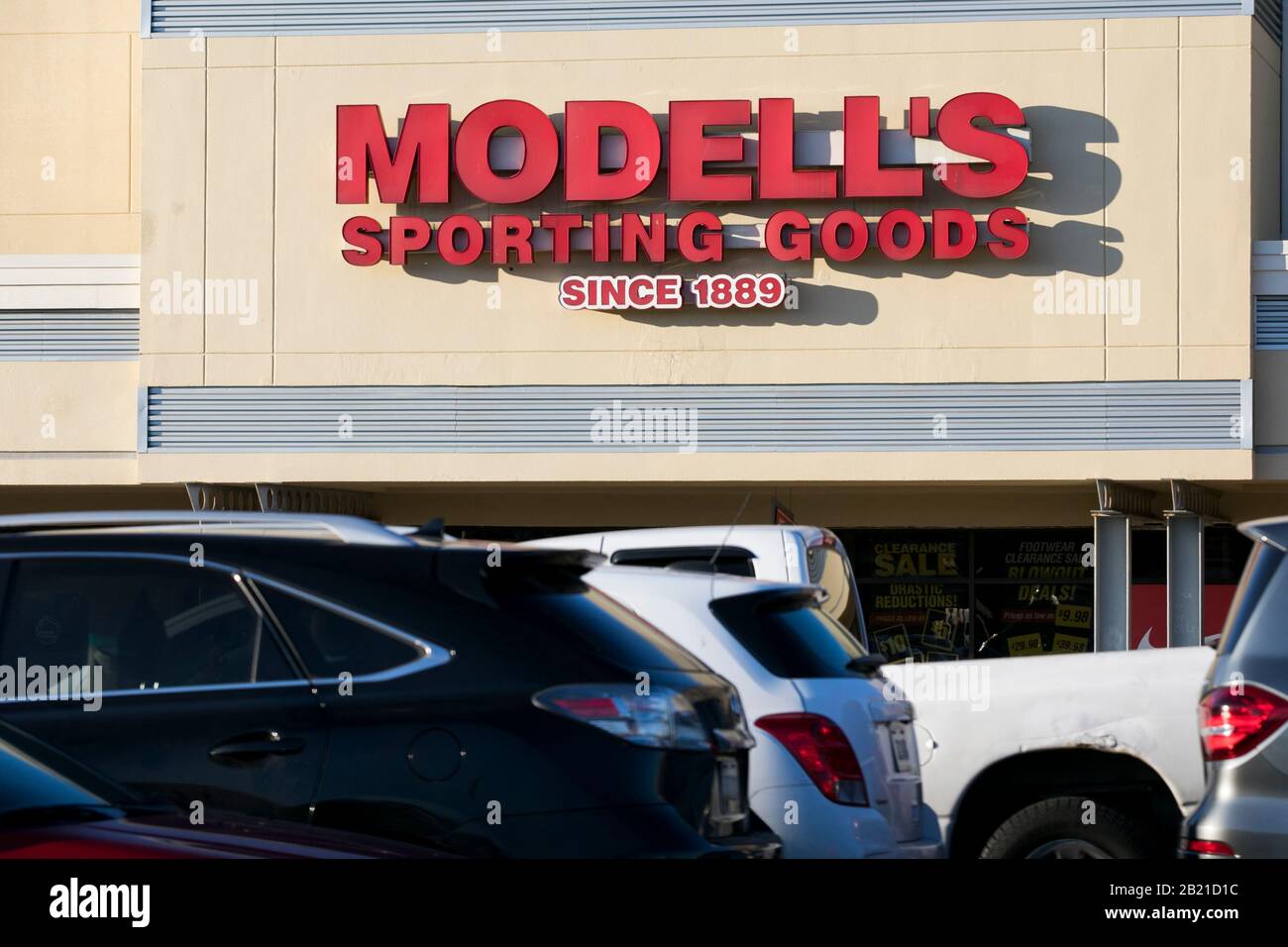 A logo sign outside of a Modell's Sporting Goods retail store location ...