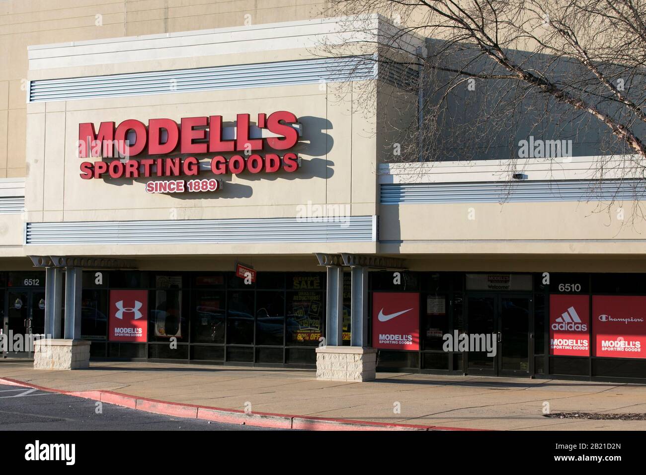 A logo sign outside of a Modell's Sporting Goods retail store location ...