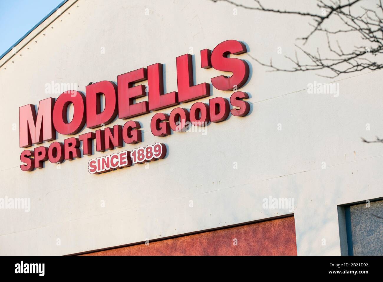 A logo sign outside of a Modell's Sporting Goods retail store location ...