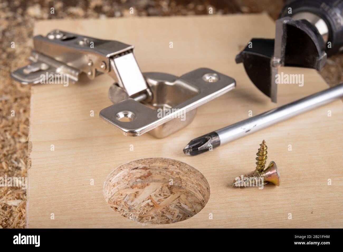 Installation of furniture hinges in chipboard. Small carpentry work in ...