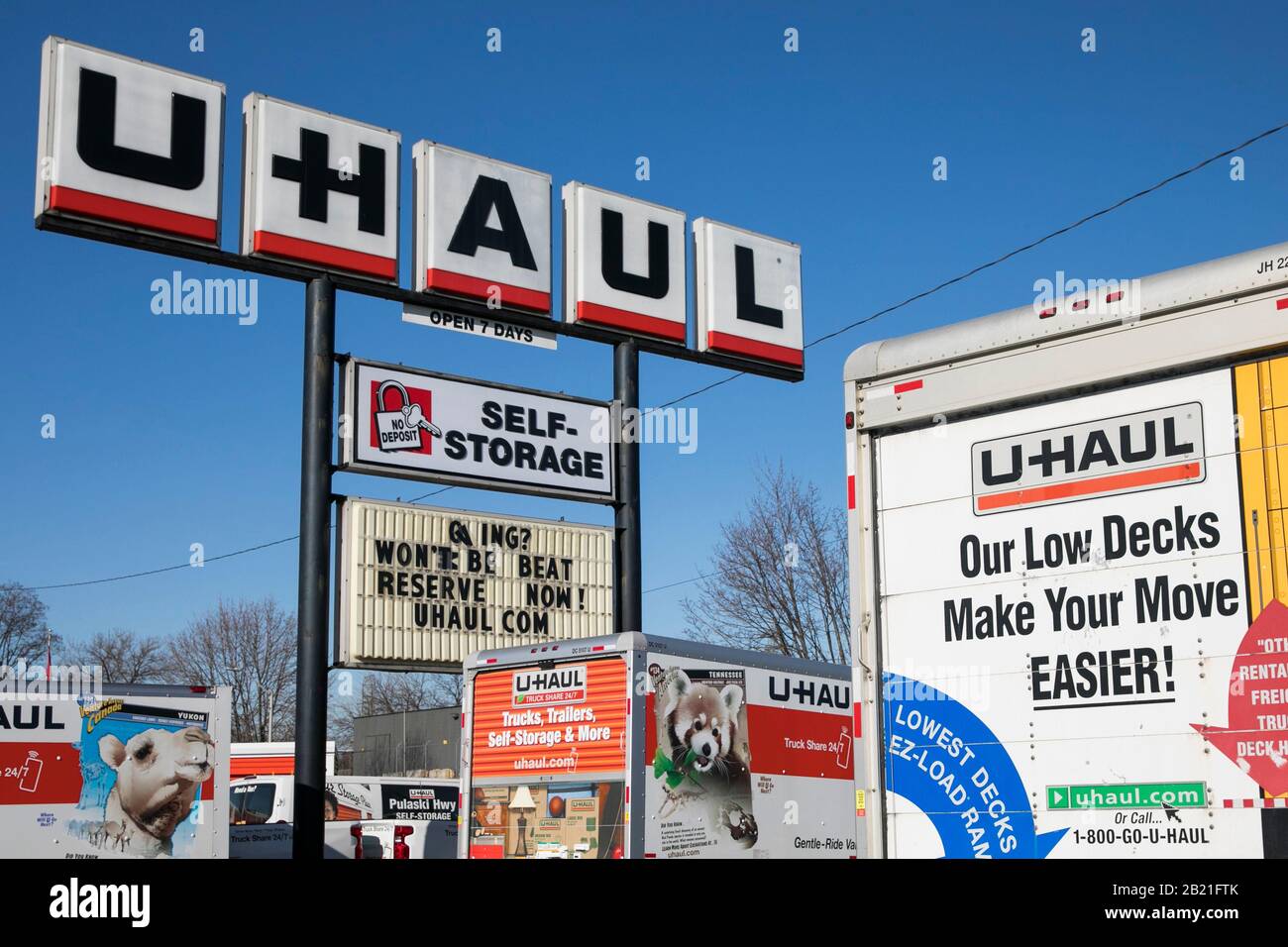 A logo sign and moving trucks outside of a U-Haul location in Baltimore ...