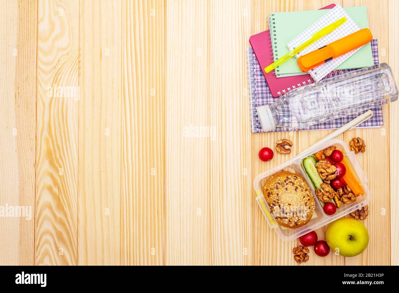 School lunch box with sandwich, fresh fruits, vegetables, and water ...