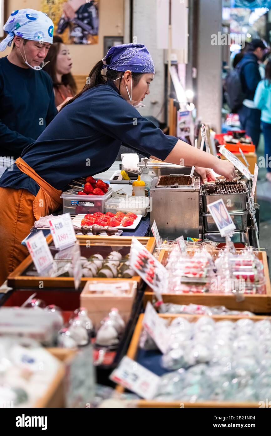 Kyoto, Japan - April 17, 2019: People serving at Nishiki market shops ...