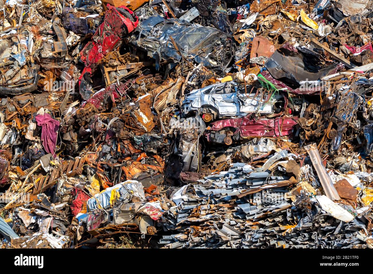 A large pile of scrap metal at a recycling yard. Unidentifiable cars ...