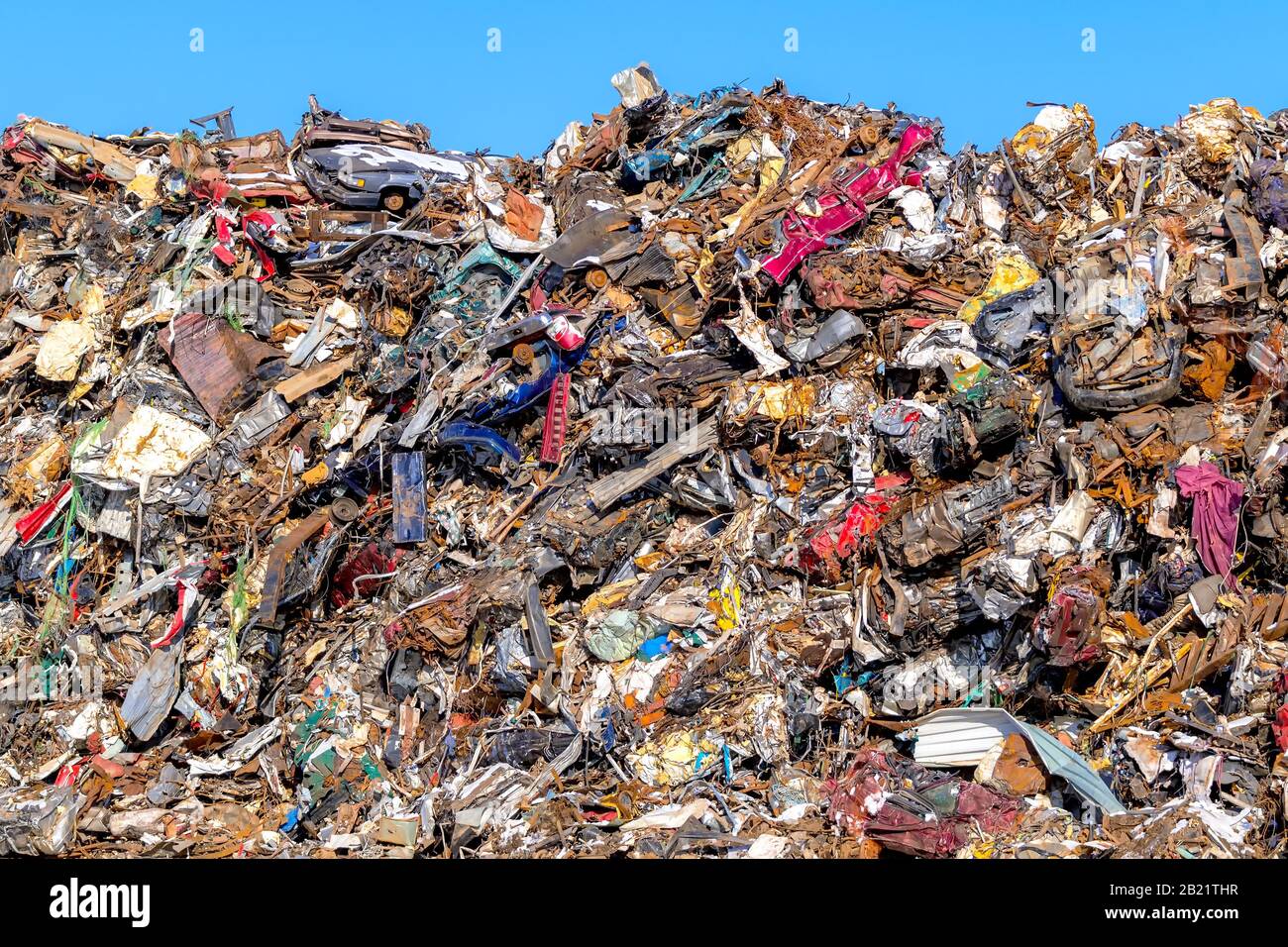 A large pile of scrap metal at a recycling yard. Unidentifiable cars ...