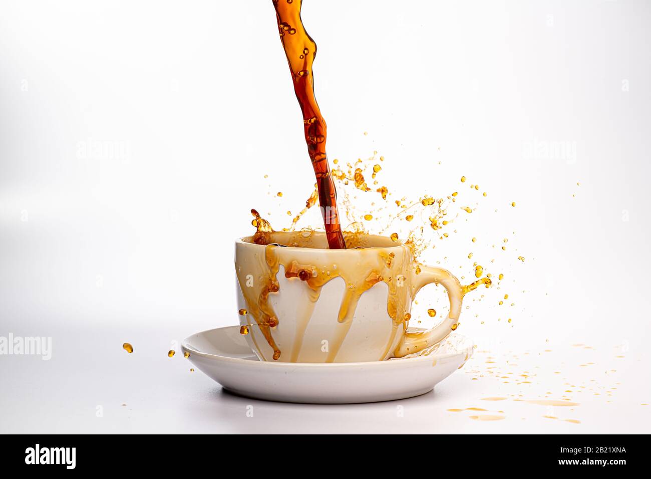 Coffee pouring into a white cup isolated against a plain white ...