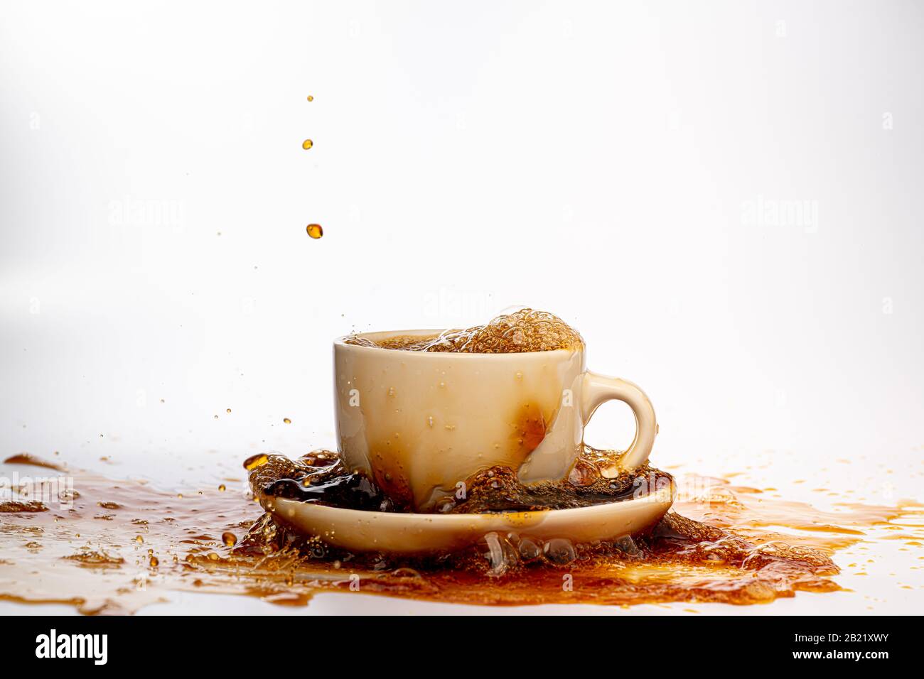 Coffee pouring into a white cup isolated against a plain white ...