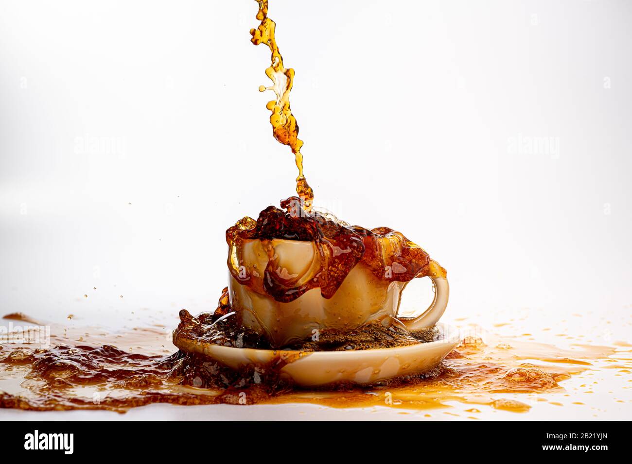 Coffee pouring into a white cup isolated against a plain white ...