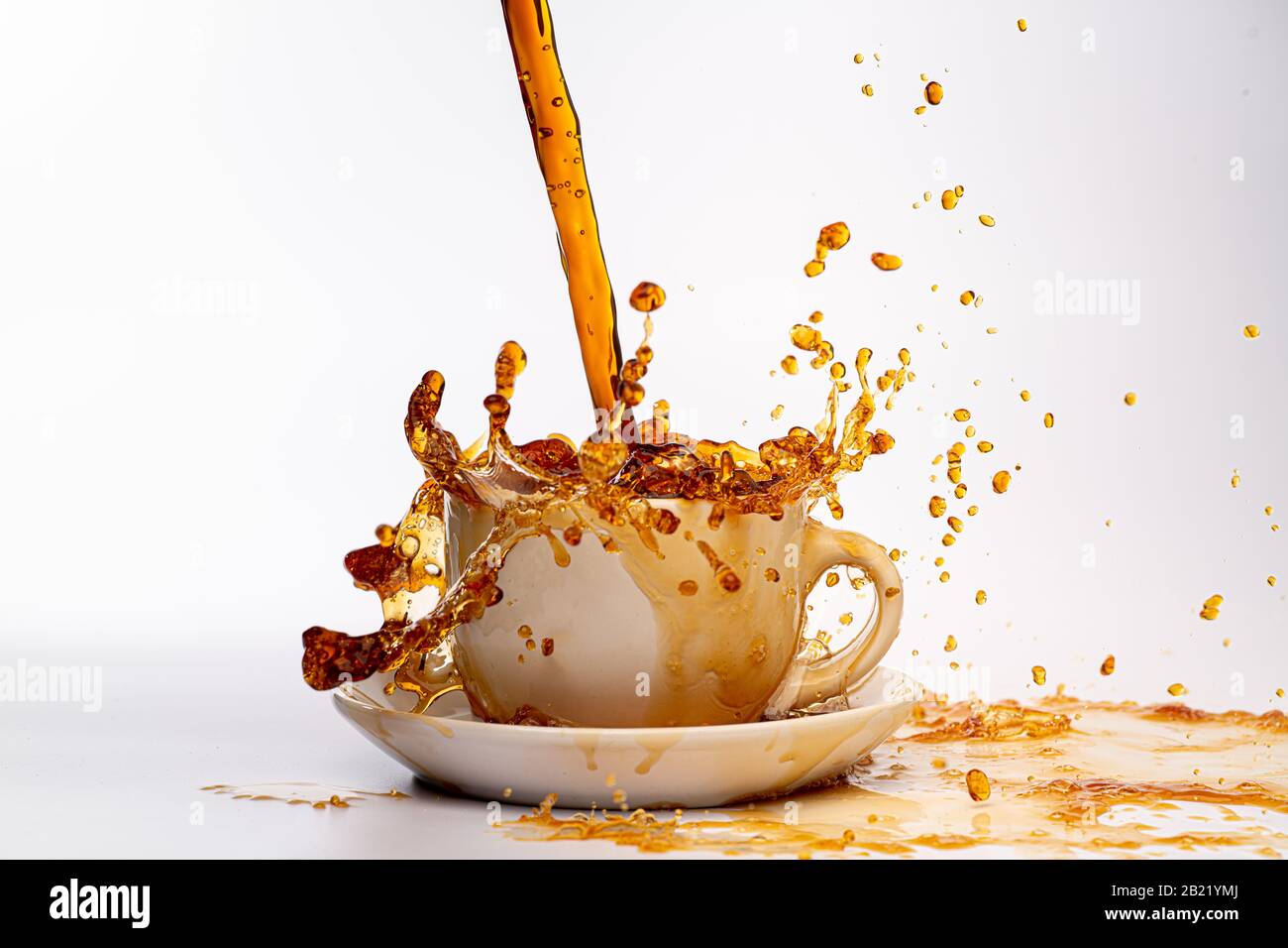 Coffee pouring into a white cup isolated against a plain white ...