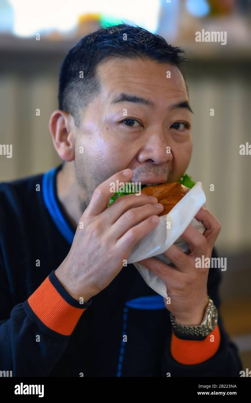 A Japanese man enjoys a burger in a diner in Tokyo Stock Photo - Alamy