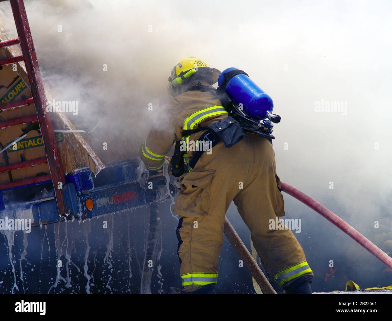 A firefighter extinguishing a vehicle fire along an Arizona road ...