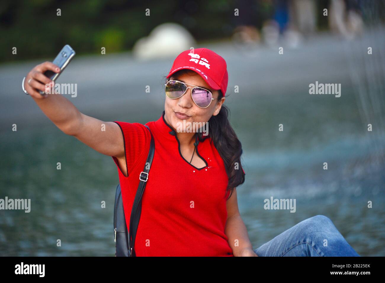 A woman wearing a Georgian cap taking a selfie in Europe square ...