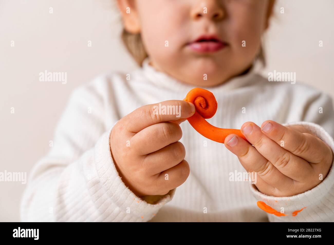 Little toddler plays play dough. Modeling orange sun. Creativity ...