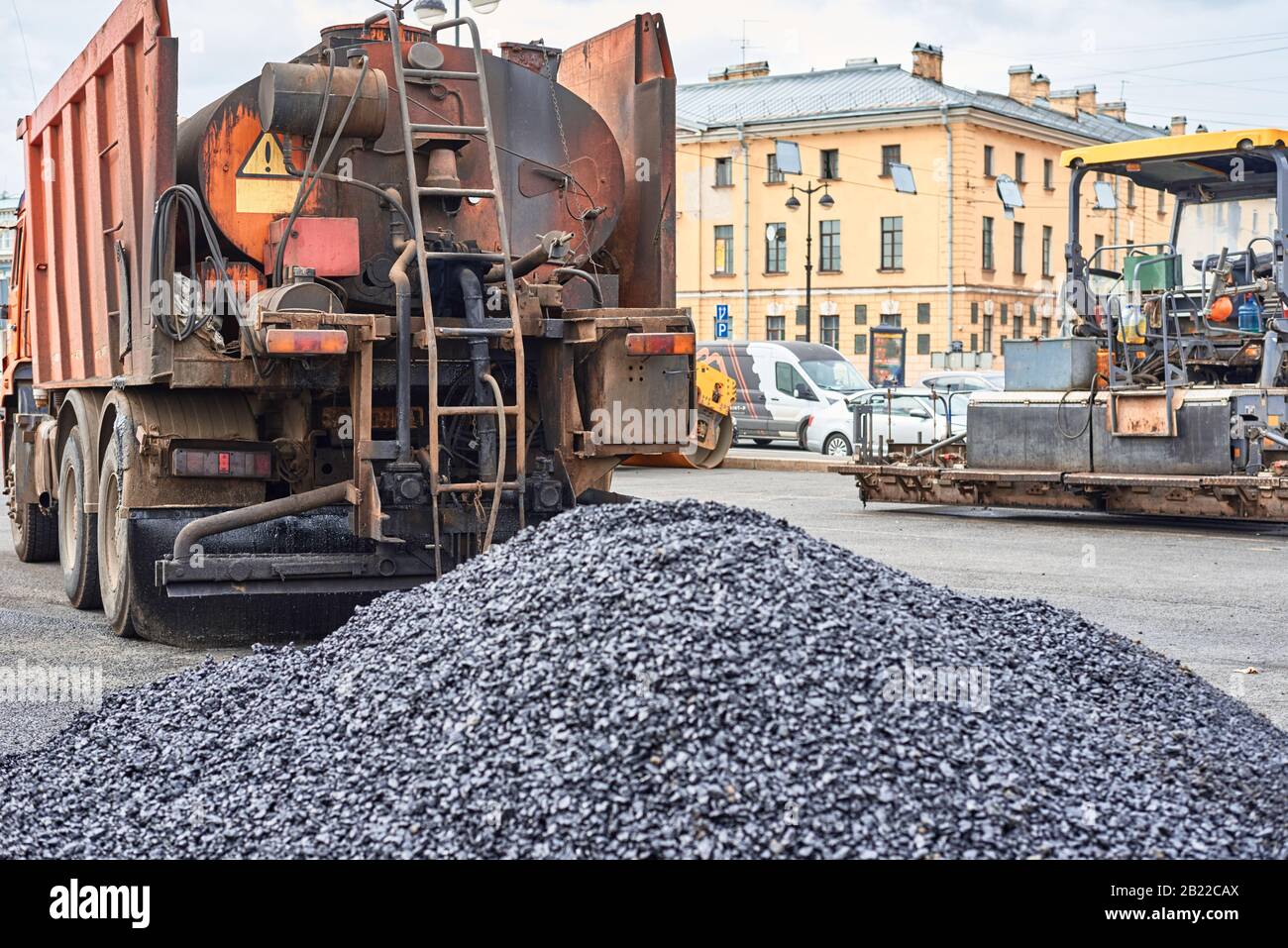 Hot asphalt and trick with bitumen in city. Road construction Stock ...