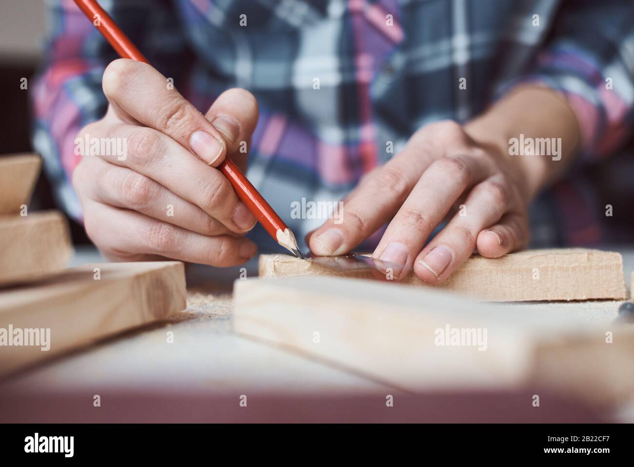 Carpenter hands taking measurement with pencil of wooden plank. Concept ...