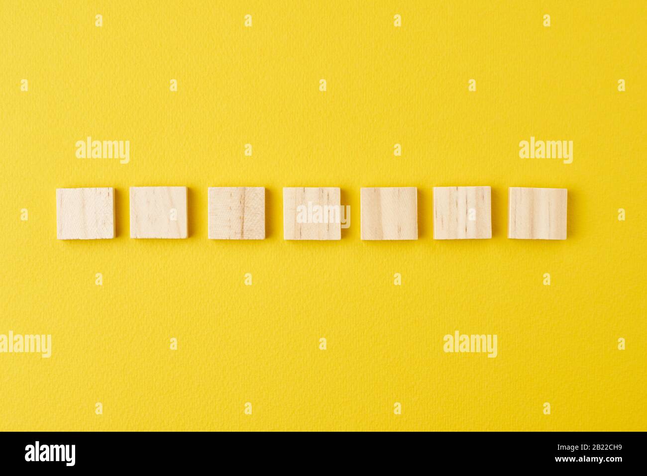 Wooden blocks in row on yellow background, top view Stock Photo - Alamy