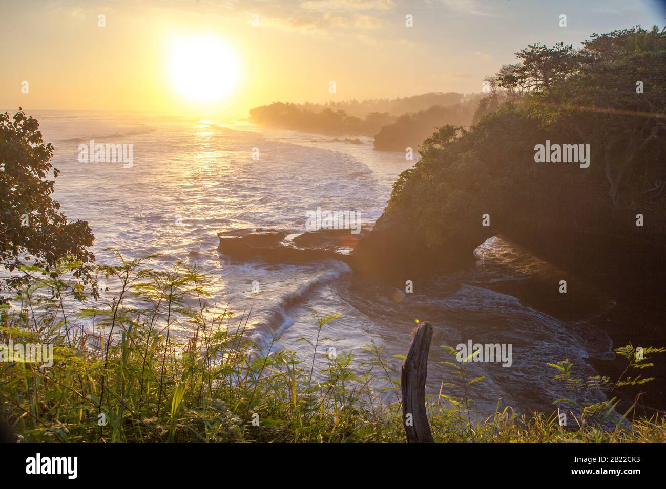 scenic elevated panoramic view of sunset over ocean and rock arch in ...