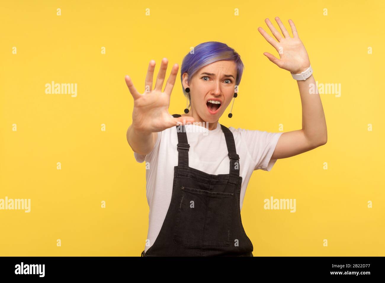 Portrait of scared hipster woman with violet short hair in denim ...