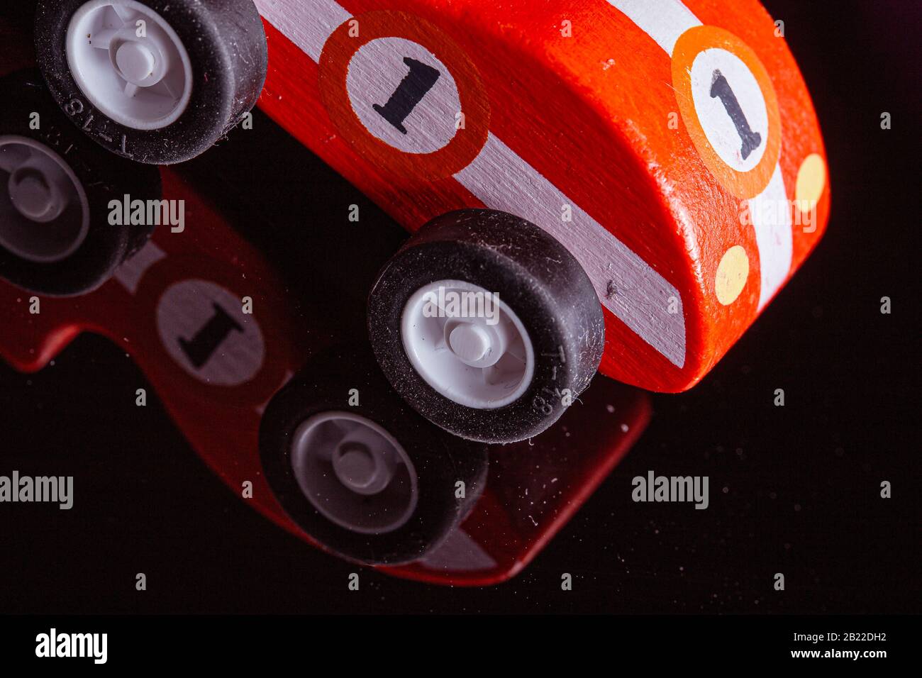Red tiny toy car on a black surface Stock Photo - Alamy