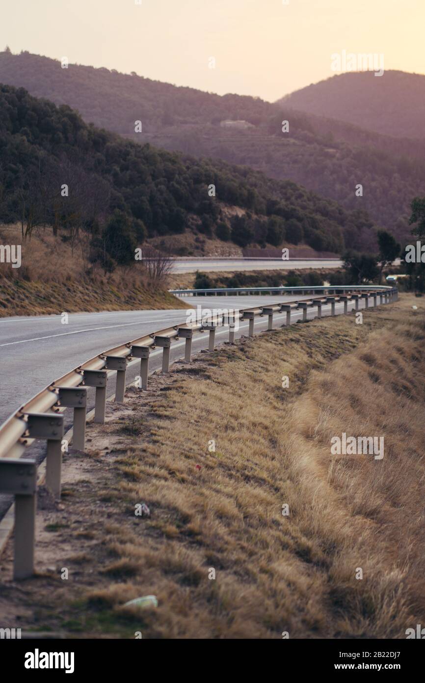 Metal fence on an empty mountain road landscape edge on a yellowish ...
