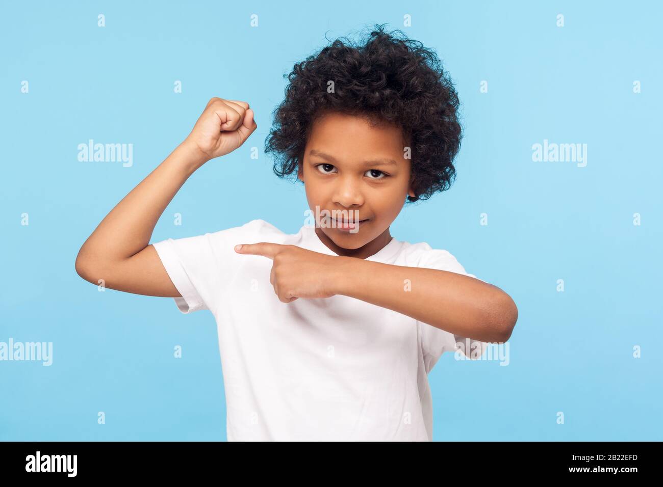 Look at my muscle, I'm strong. Portrait of adorable little boy in T ...