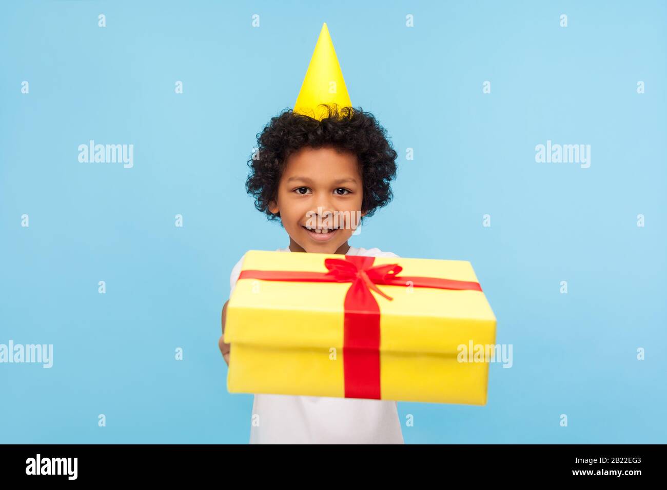 Generous kind adorable little boy with funny party cone on head smiling ...
